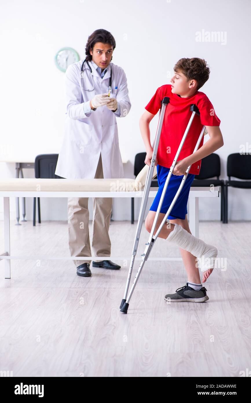 Leg injured boy visiting young doctor traumatologist Stock Photo - Alamy
