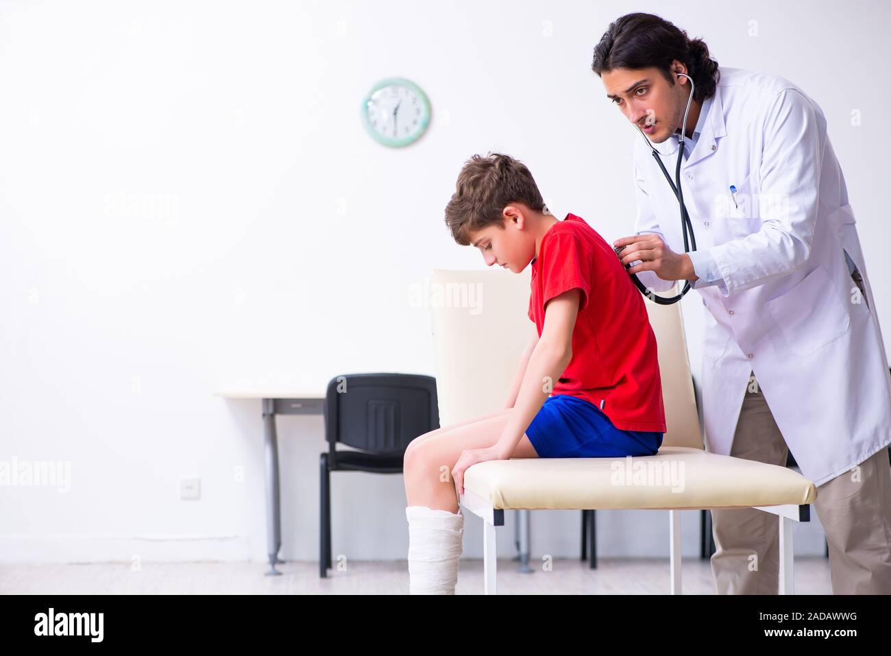 Leg injured boy visiting young doctor traumatologist Stock Photo - Alamy