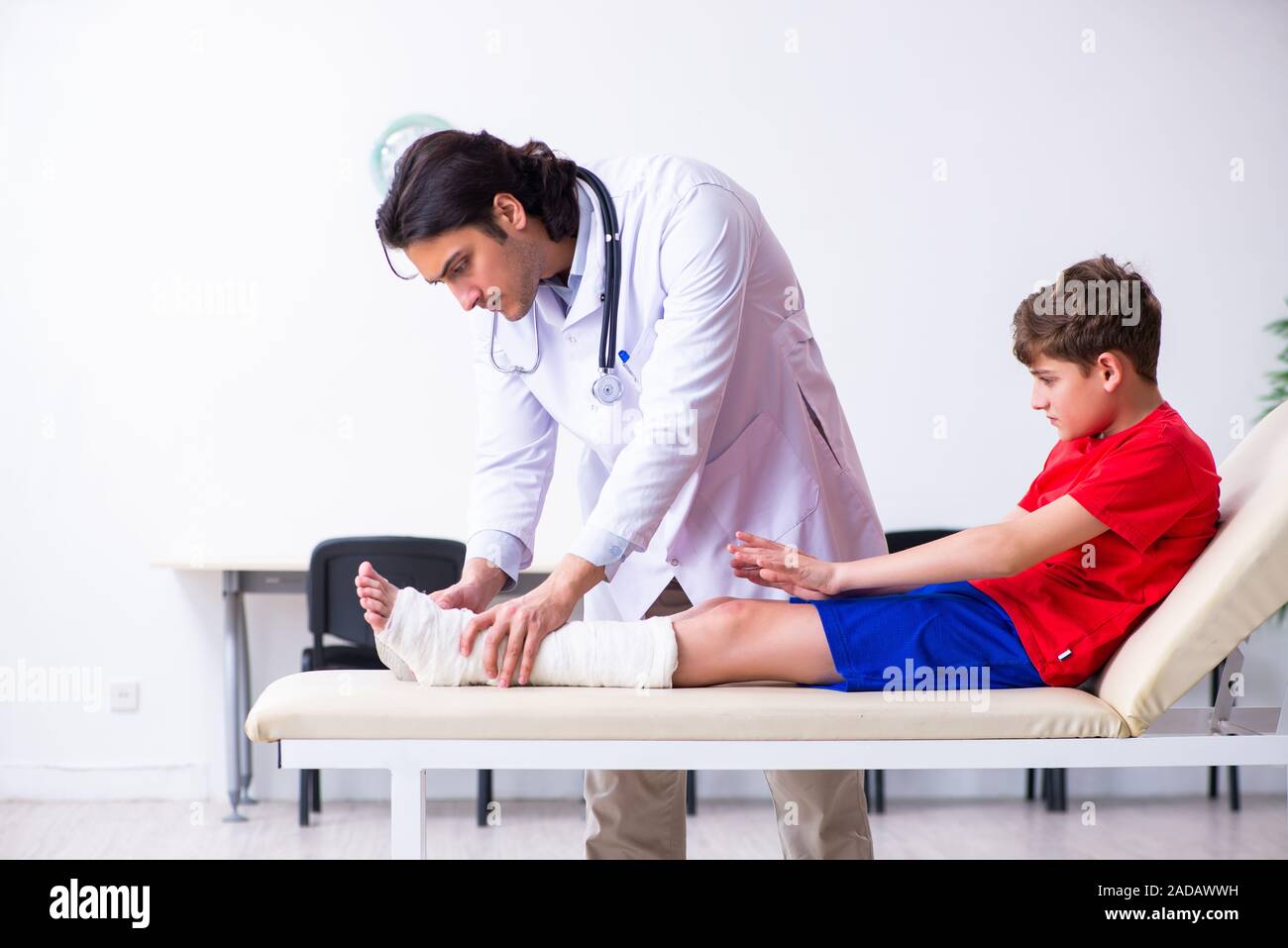 Leg injured boy visiting young doctor traumatologist Stock Photo - Alamy