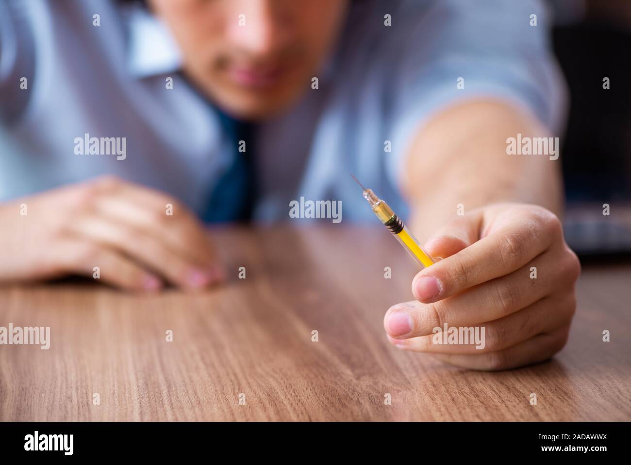 Young man having problems with narcotics at workplace Stock Photo - Alamy