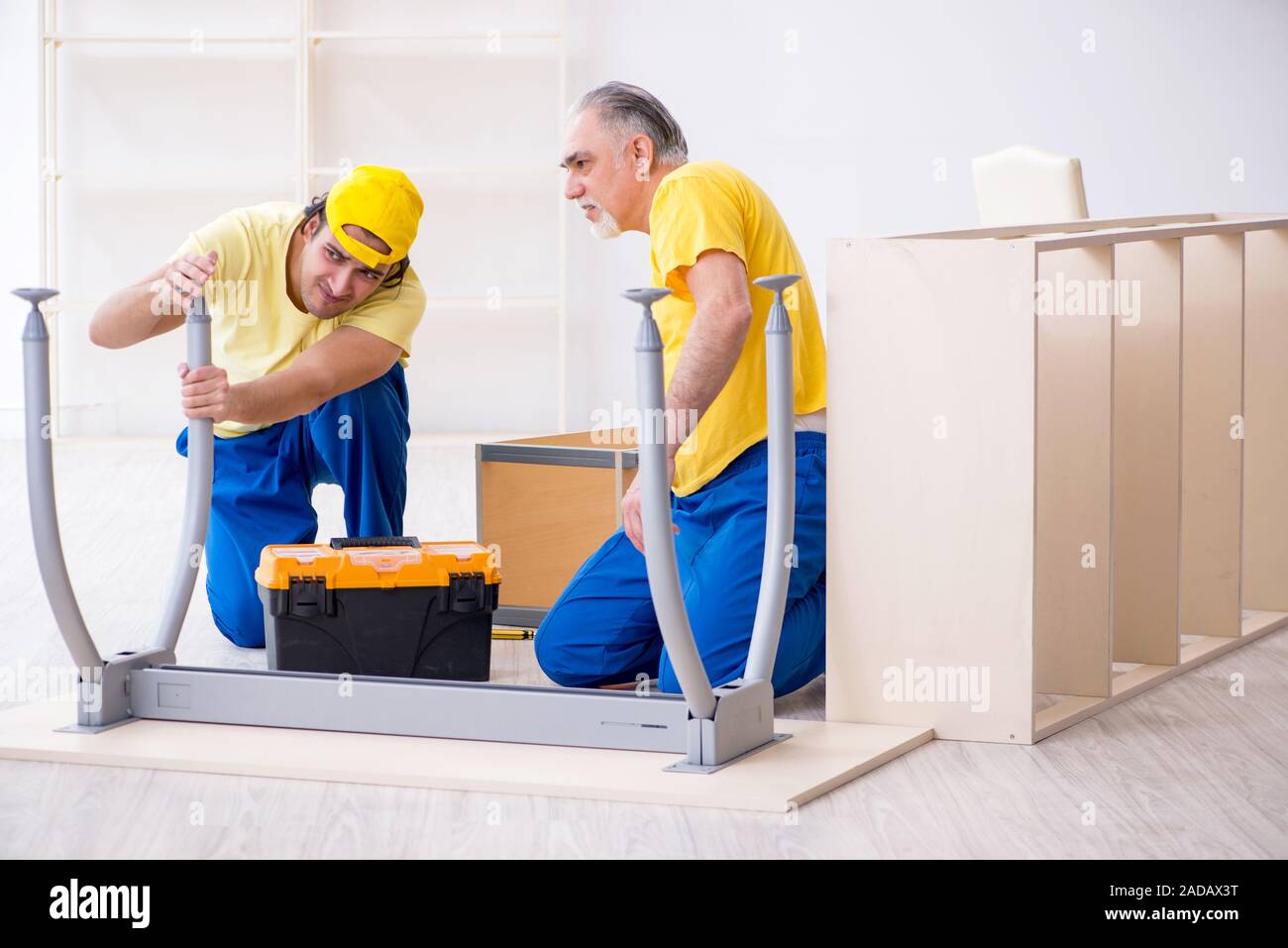Two contractors carpenters working indoors Stock Photo - Alamy
