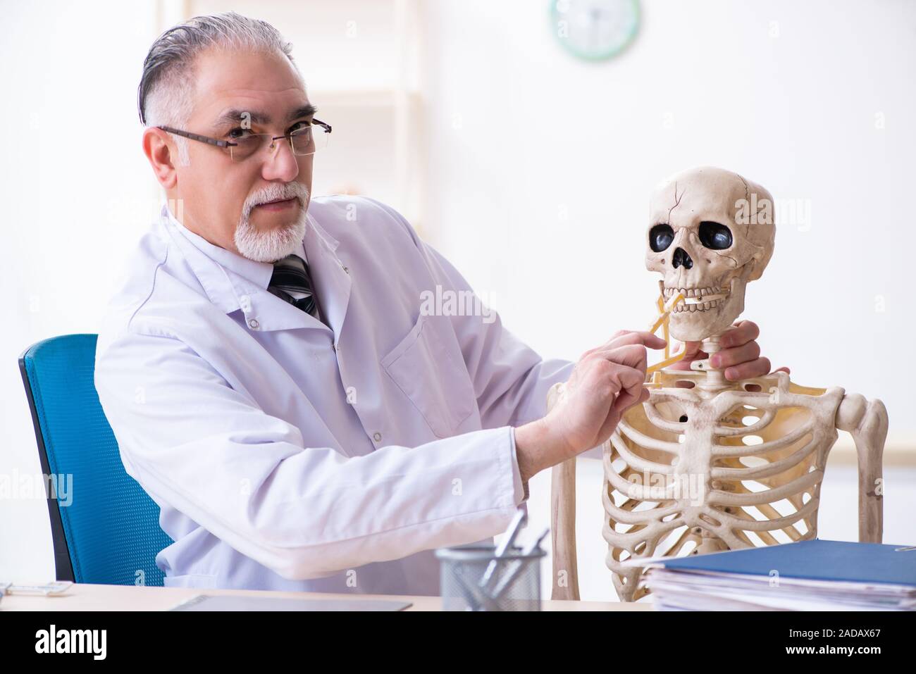 Aged male doctor with skeleton Stock Photo - Alamy