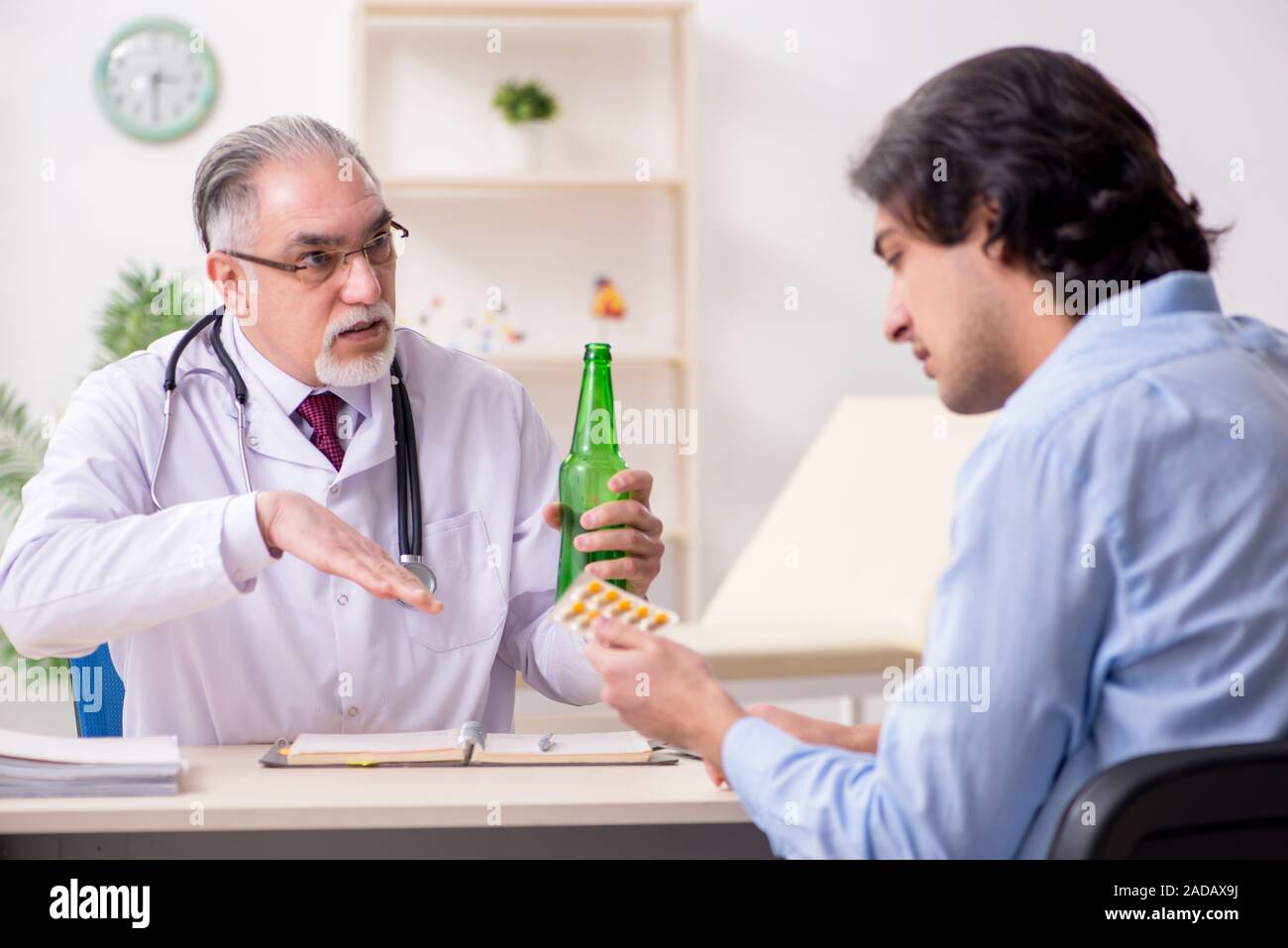 Young male alcoholic visiting old doctor Stock Photo - Alamy