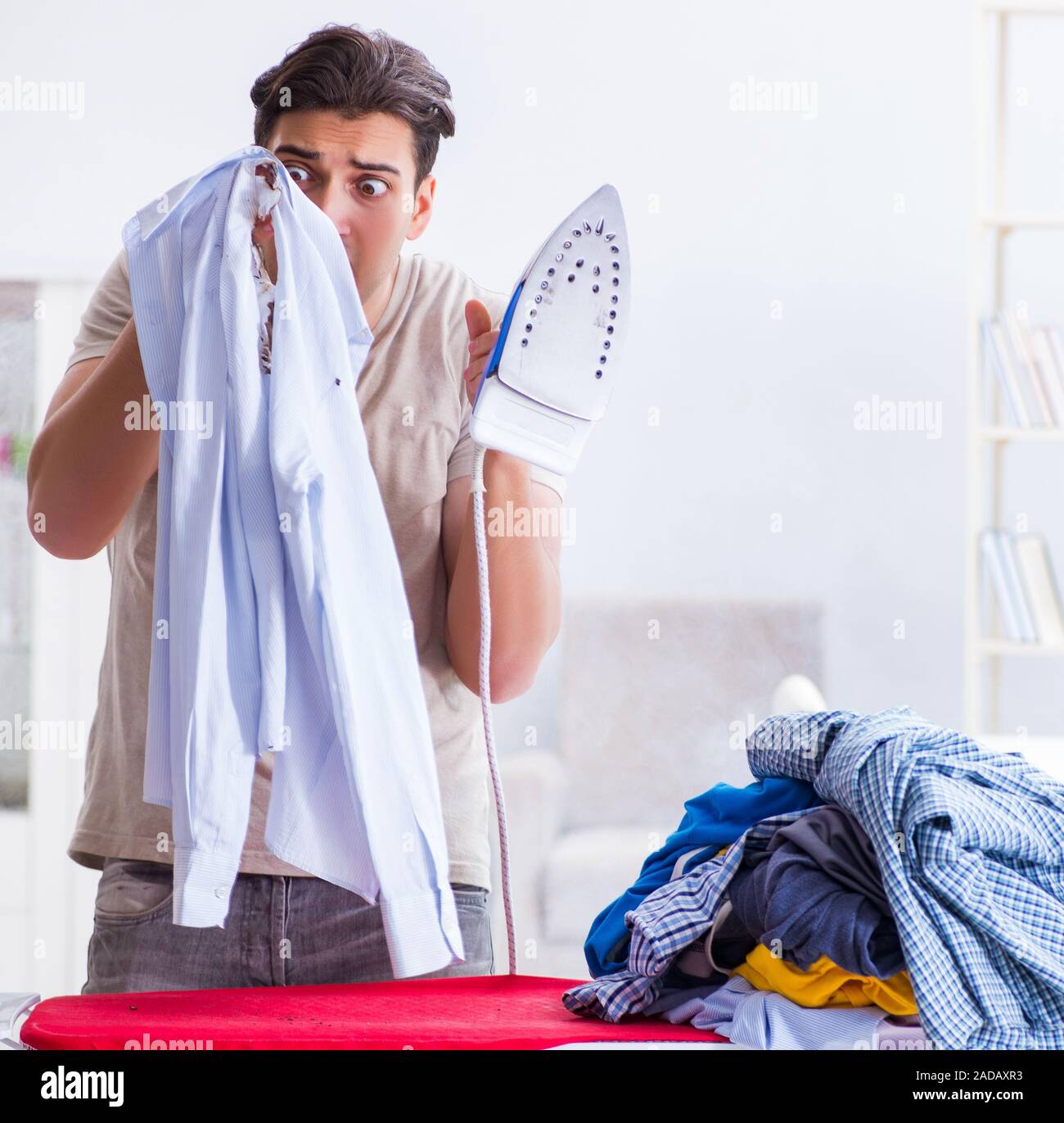Inattentive husband burning clothing while ironing Stock Photo - Alamy