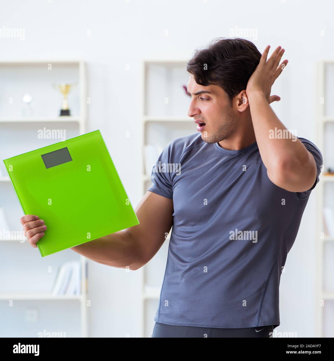 Man with scales in sports and health concept Stock Photo - Alamy
