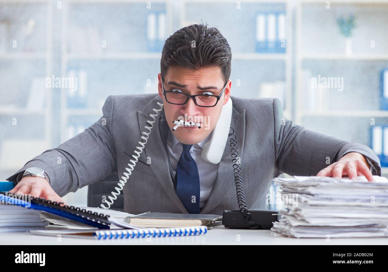Businessman smoking in office at work Stock Photo - Alamy