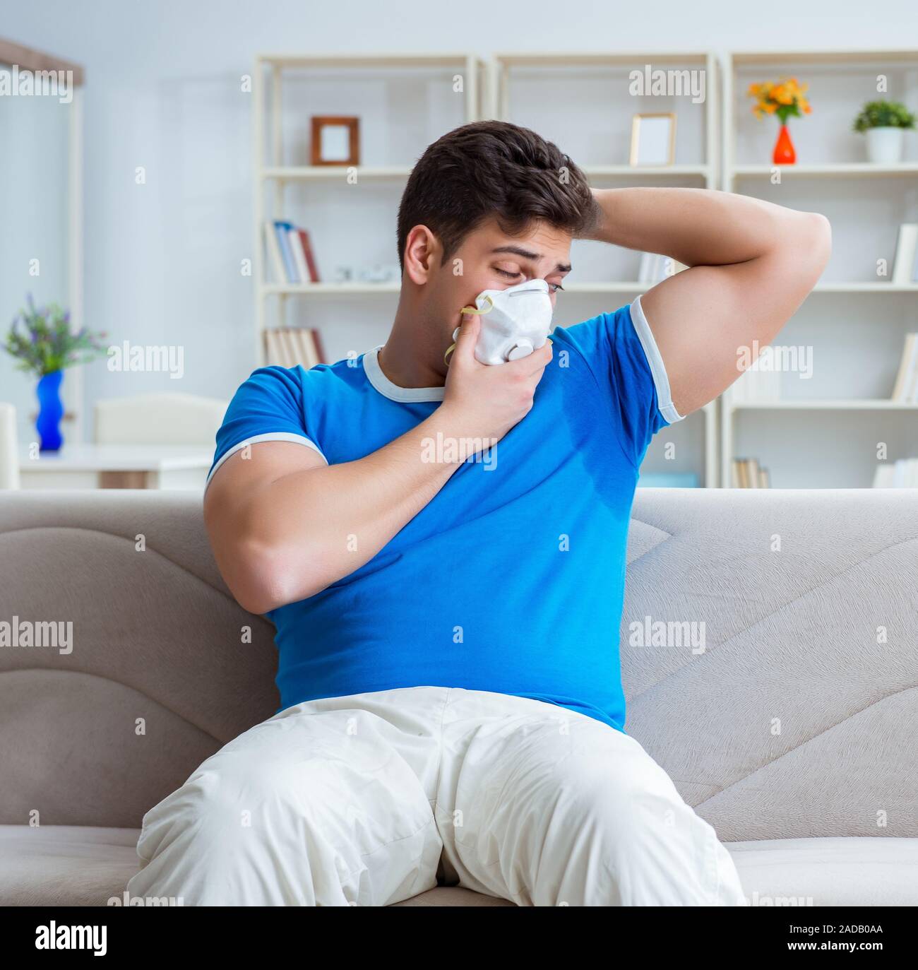 Man sweating excessively smelling bad at home Stock Photo - Alamy