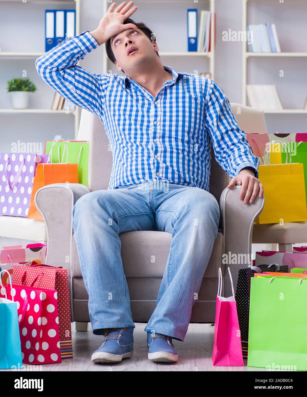 Young man after excessive shopping at home Stock Photo - Alamy