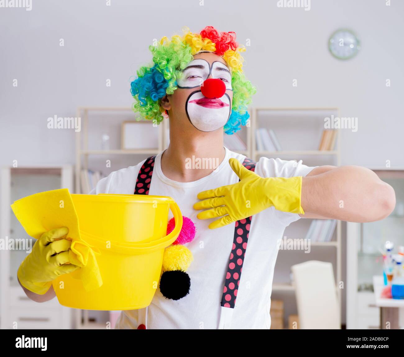 Funny clown doing cleaning at home Stock Photo - Alamy