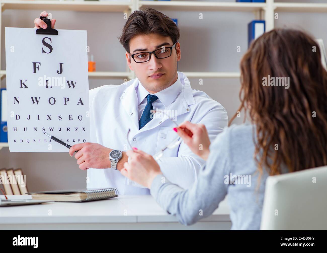 Doctor optician with letter chart conducting an eye test check Stock ...