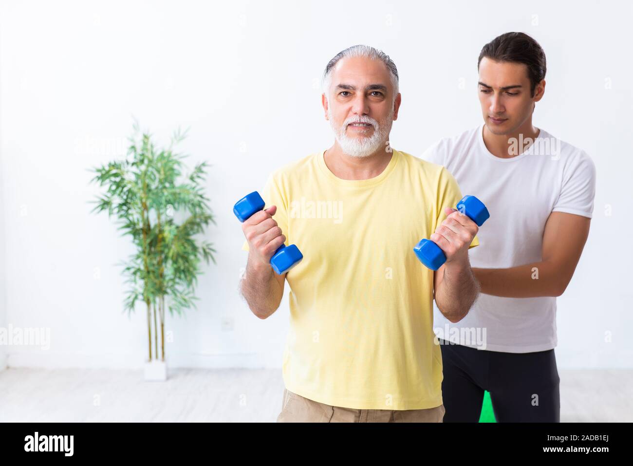 Old man doing exercises indoors Stock Photo - Alamy