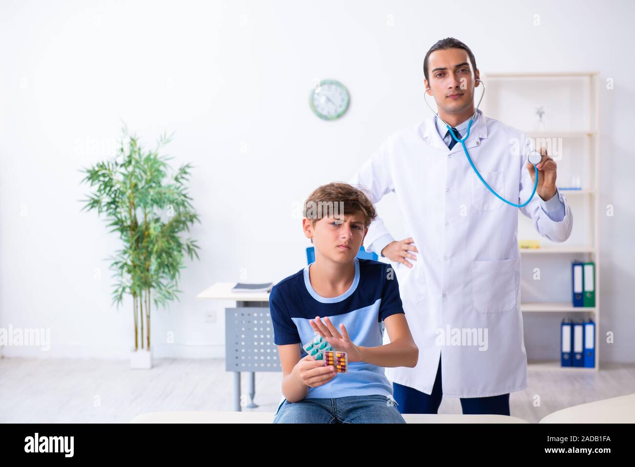 Young male doctor examining boy in the clinic Stock Photo - Alamy