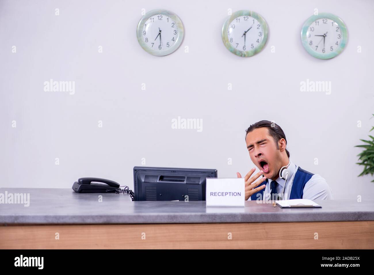 Young man receptionist at the hotel counter Stock Photo - Alamy