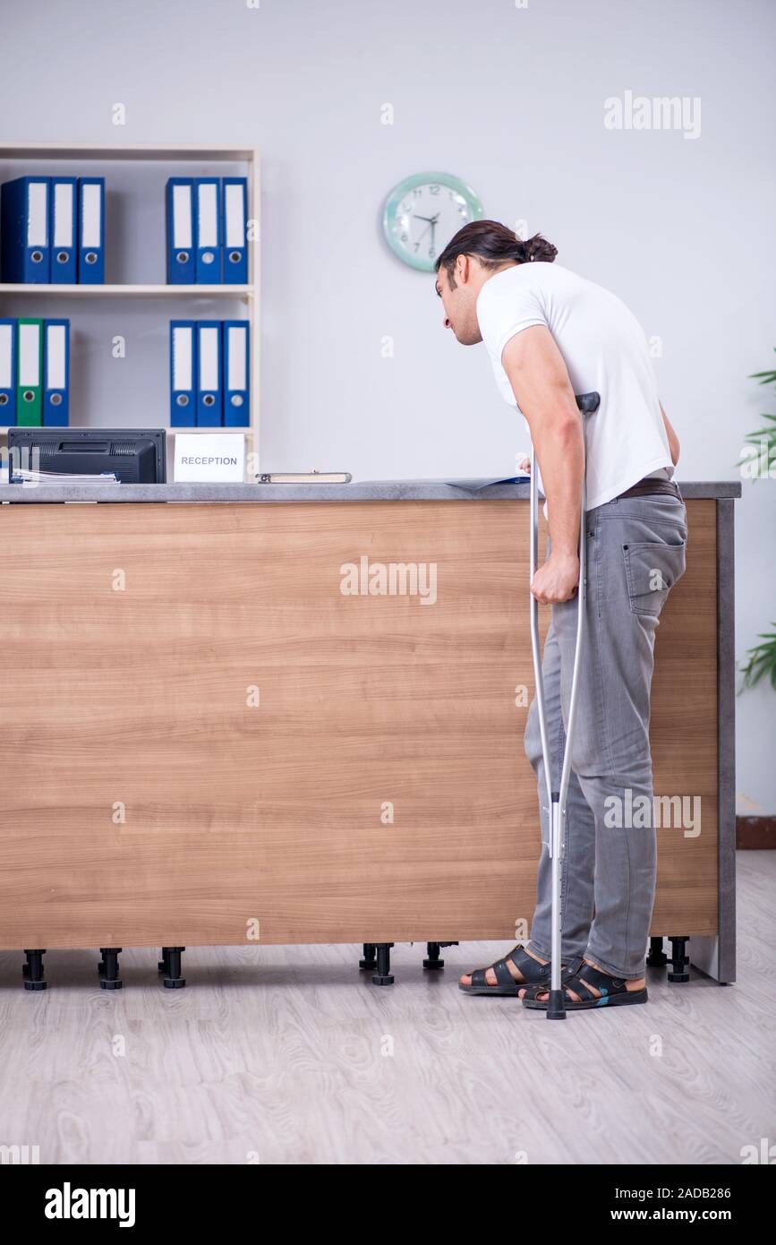 Young man at hospital reception desk Stock Photo - Alamy