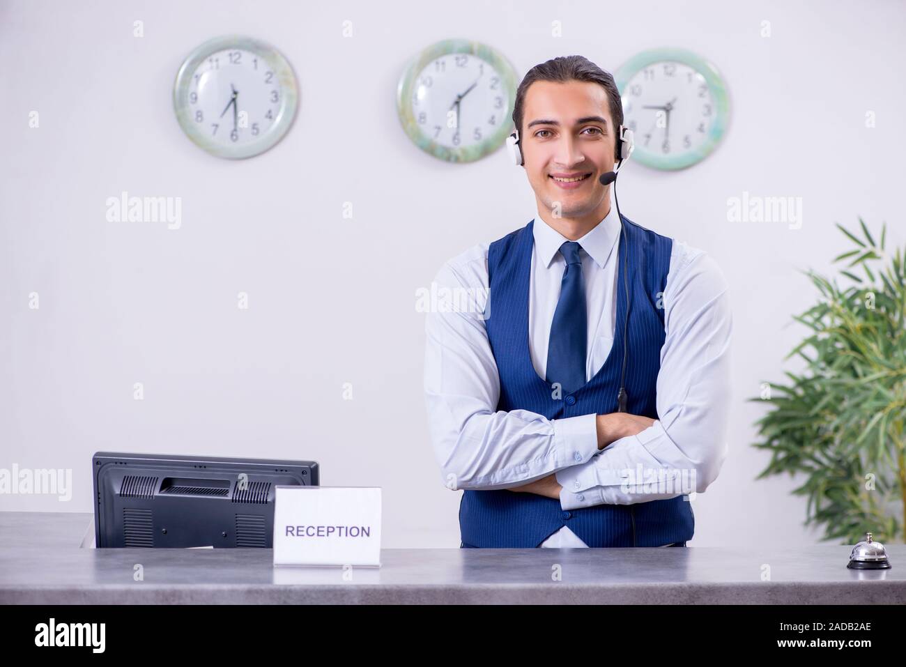 Young man receptionist at the hotel counter Stock Photo - Alamy