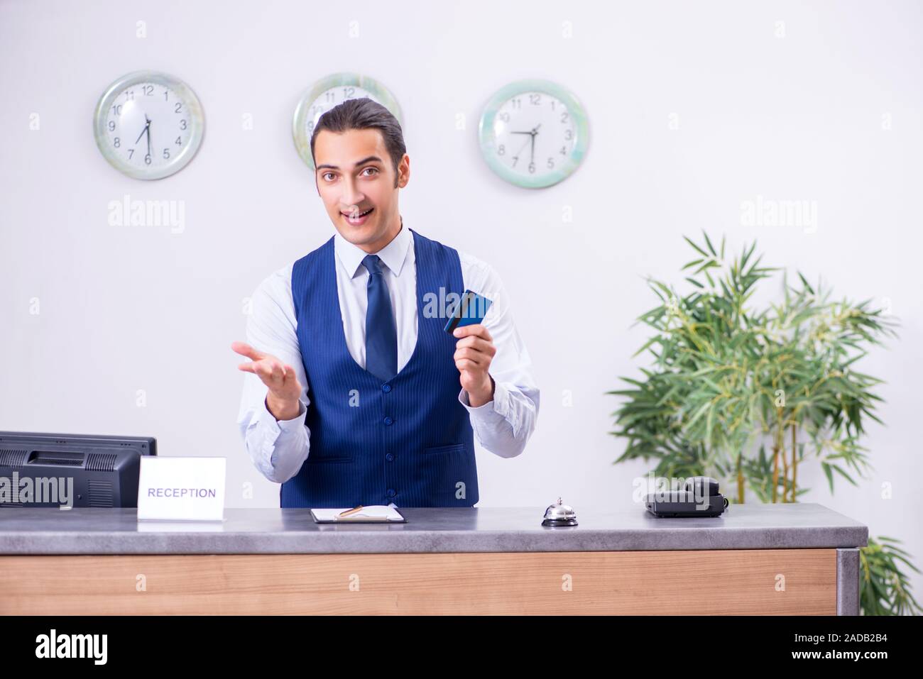 Young man receptionist at the hotel counter Stock Photo - Alamy