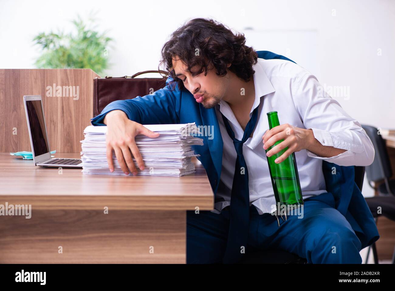 Young drunk employee in the office Stock Photo - Alamy