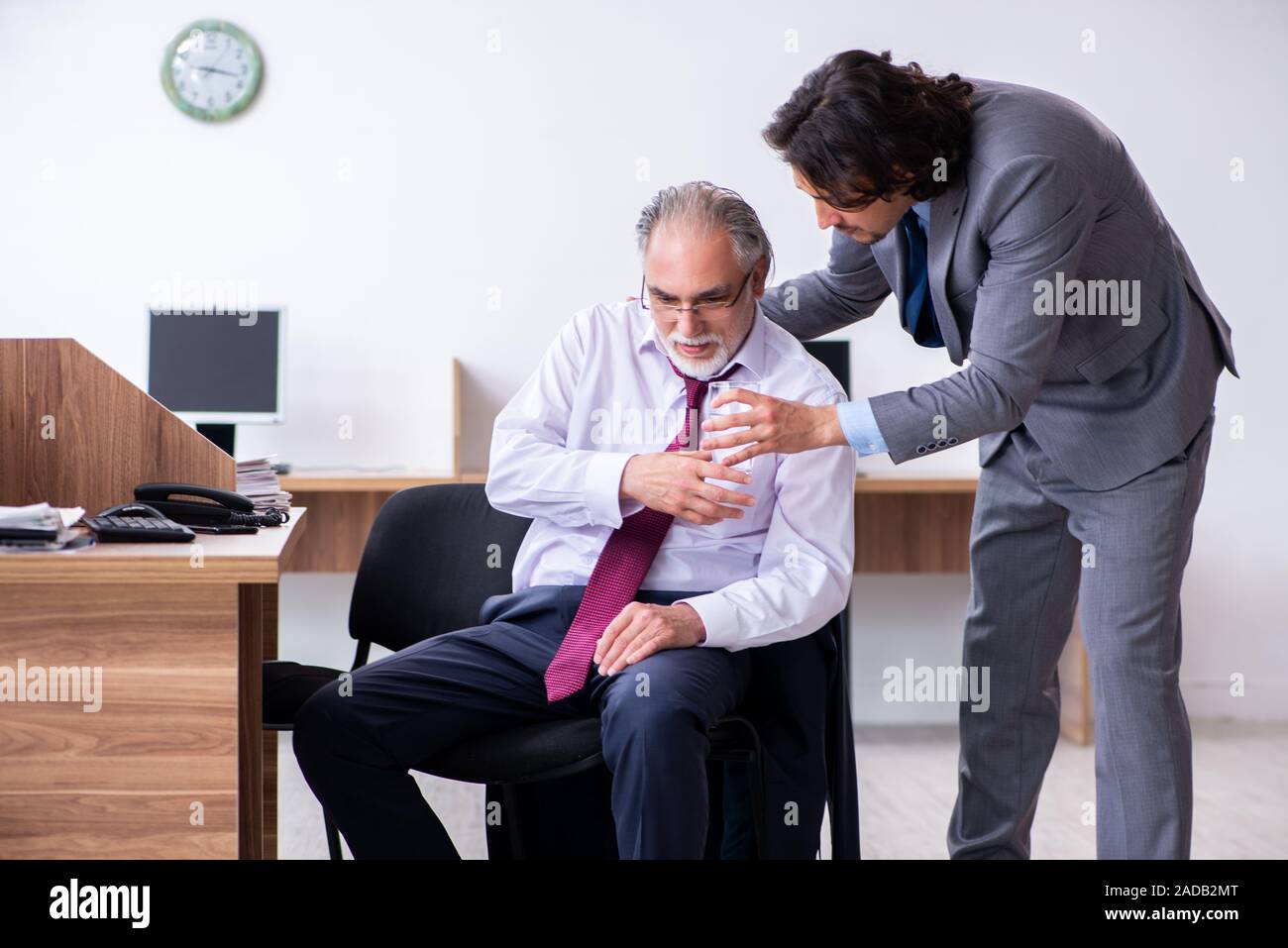 Male employee suffering from heart attack in the office Stock Photo - Alamy