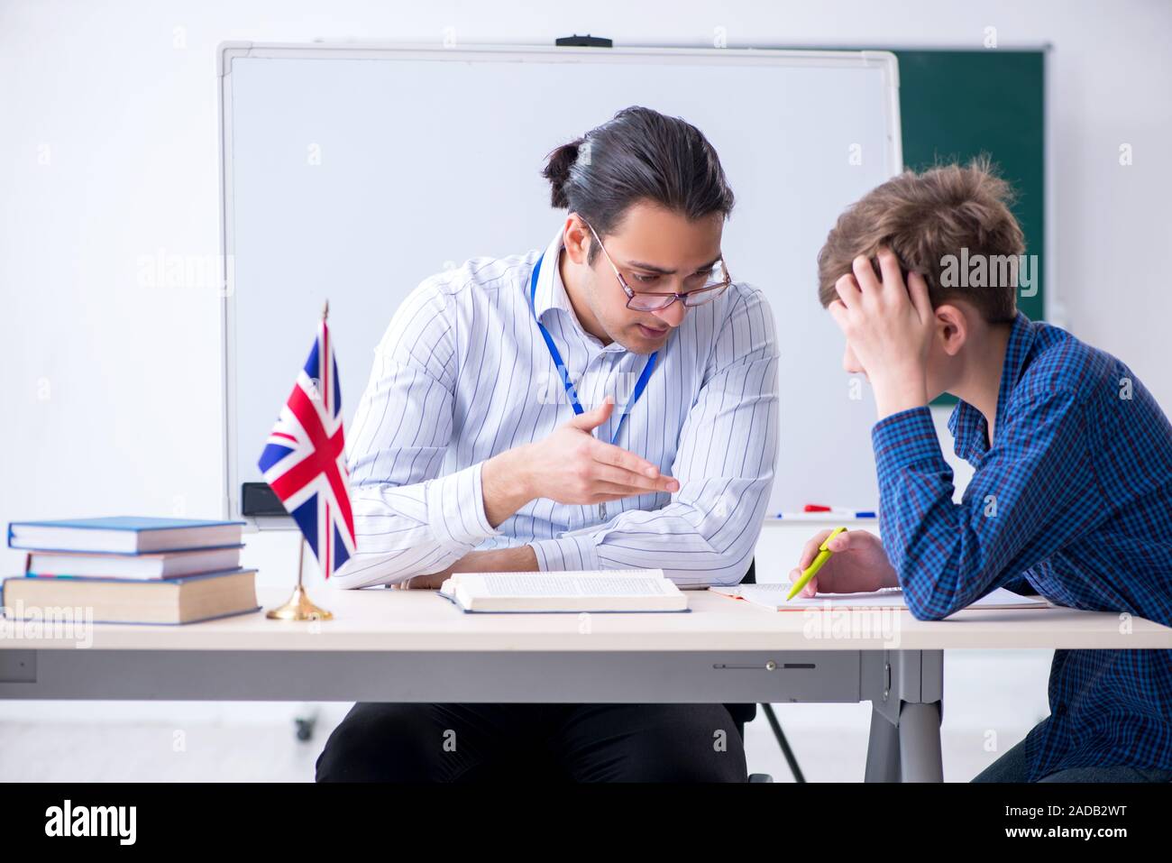 Male english teacher and boy in the classroom Stock Photo - Alamy