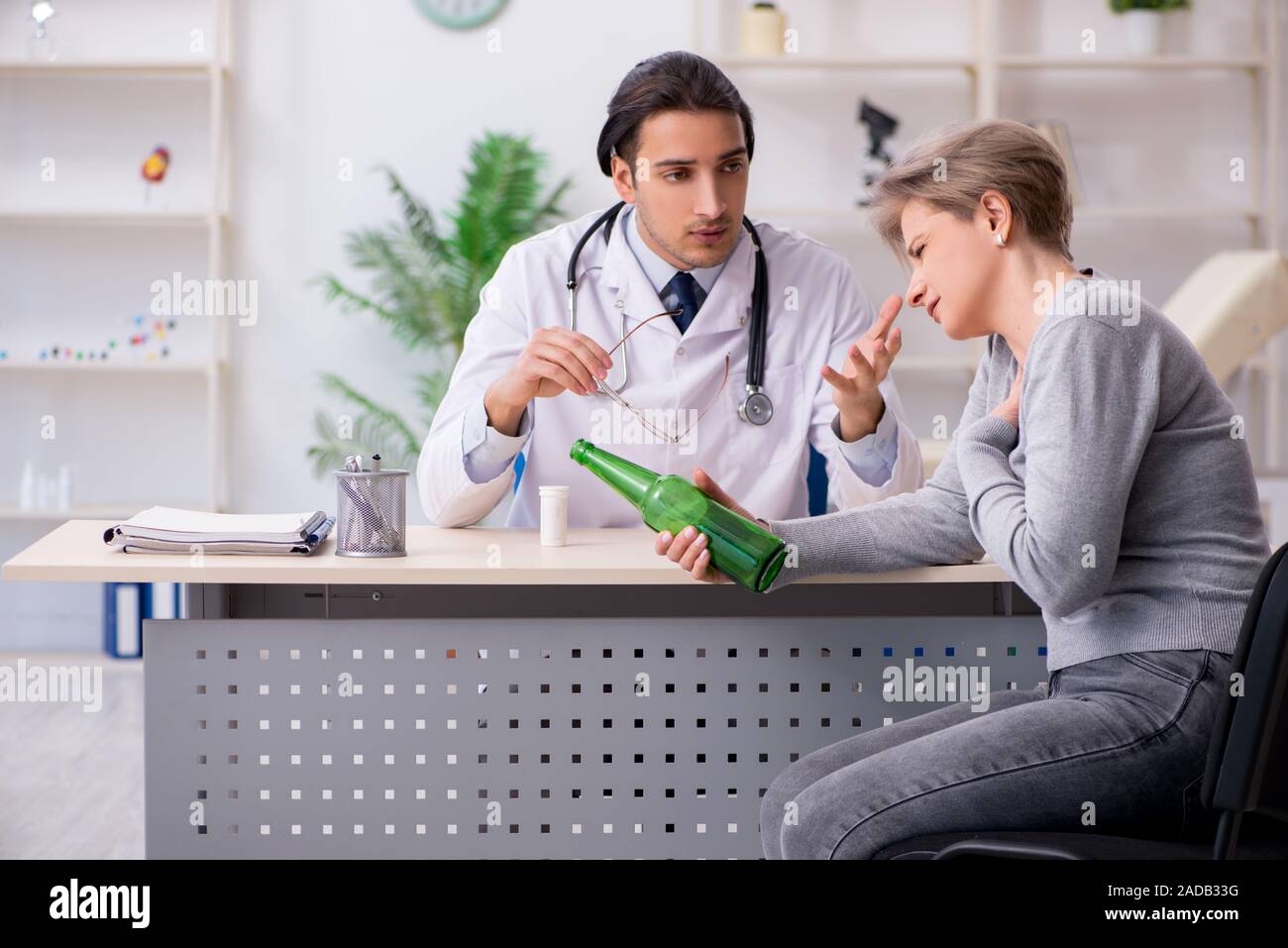 Female alcoholic visiting young male doctor Stock Photo - Alamy