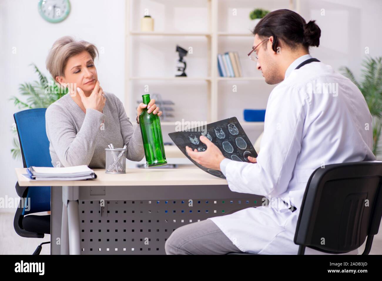 Female alcoholic visiting young male doctor Stock Photo - Alamy