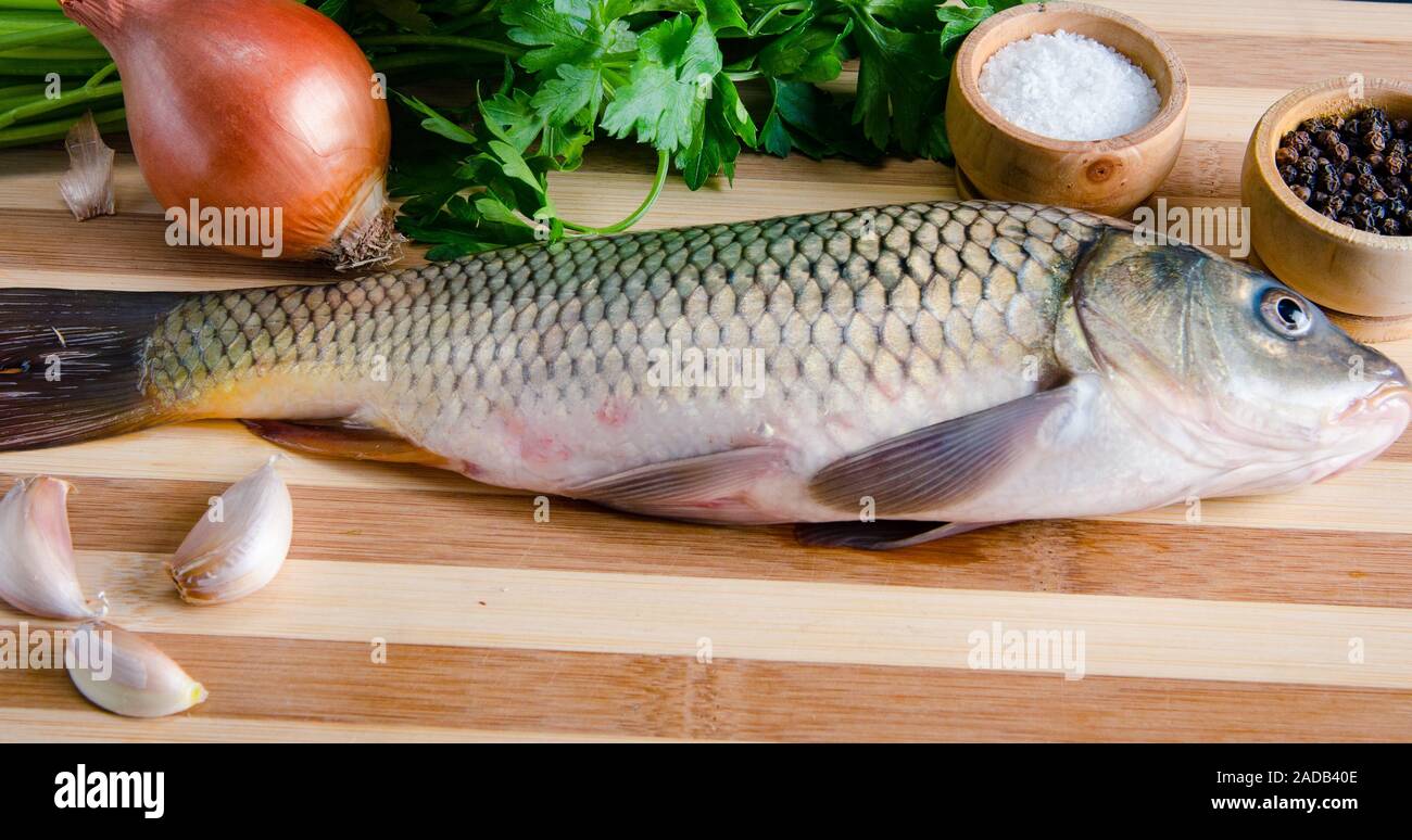 The uncooked fish on cutting board in meal preparation concept Stock ...