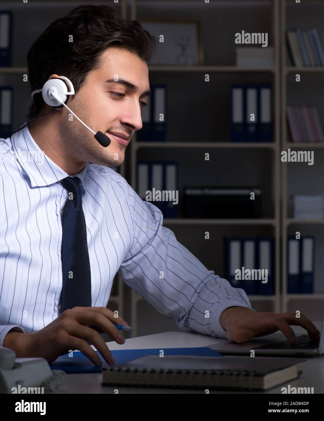 Call center operator talking to customer during night shift Stock Photo ...
