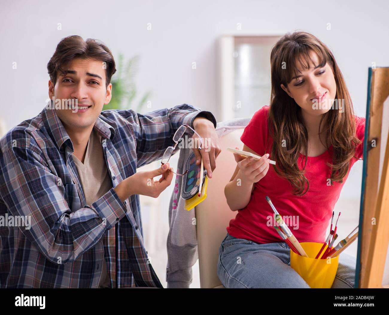 The artist coaching student in painting class in studio Stock Photo - Alamy