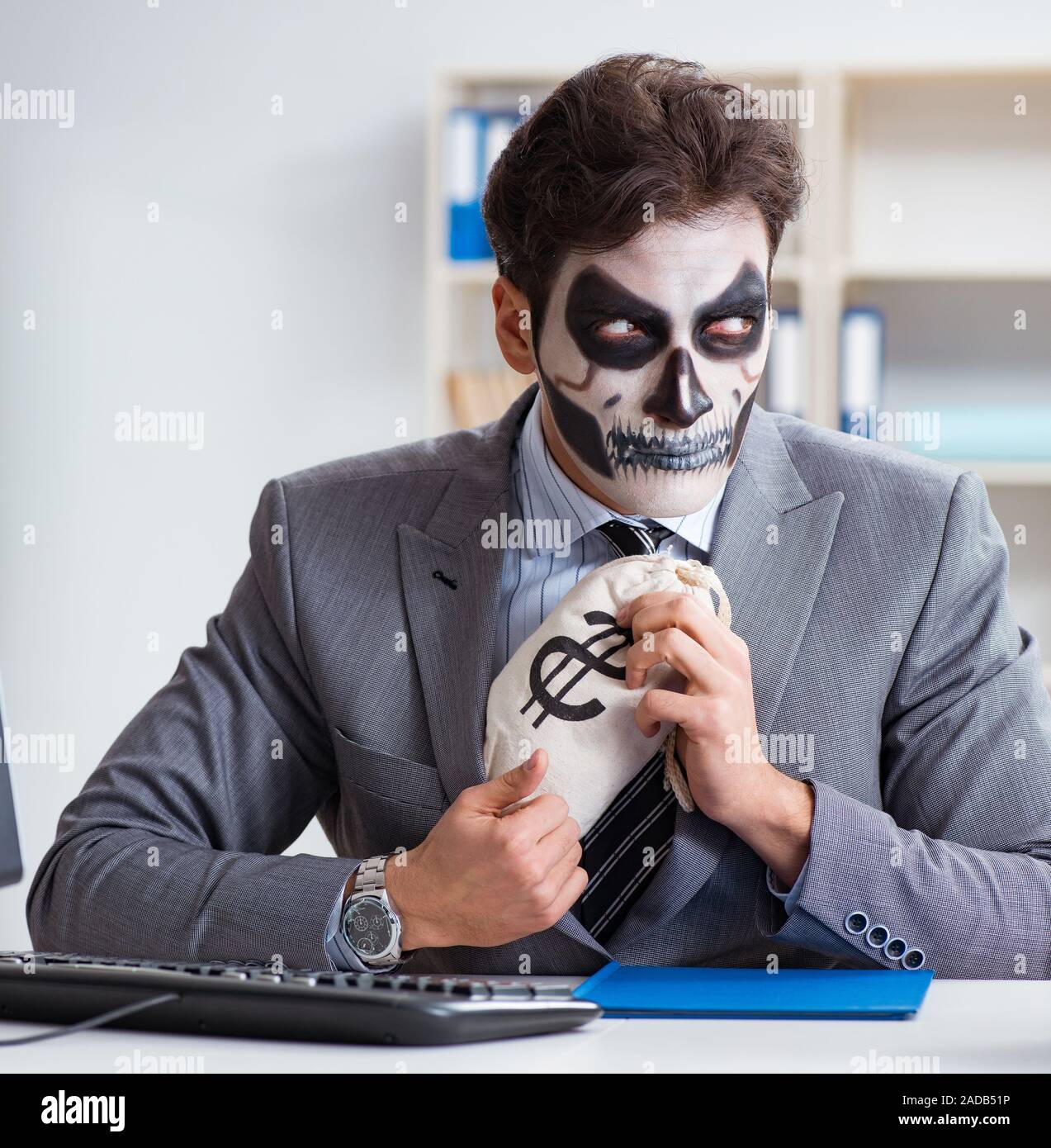 Businessmsn with scary face mask working in office Stock Photo - Alamy