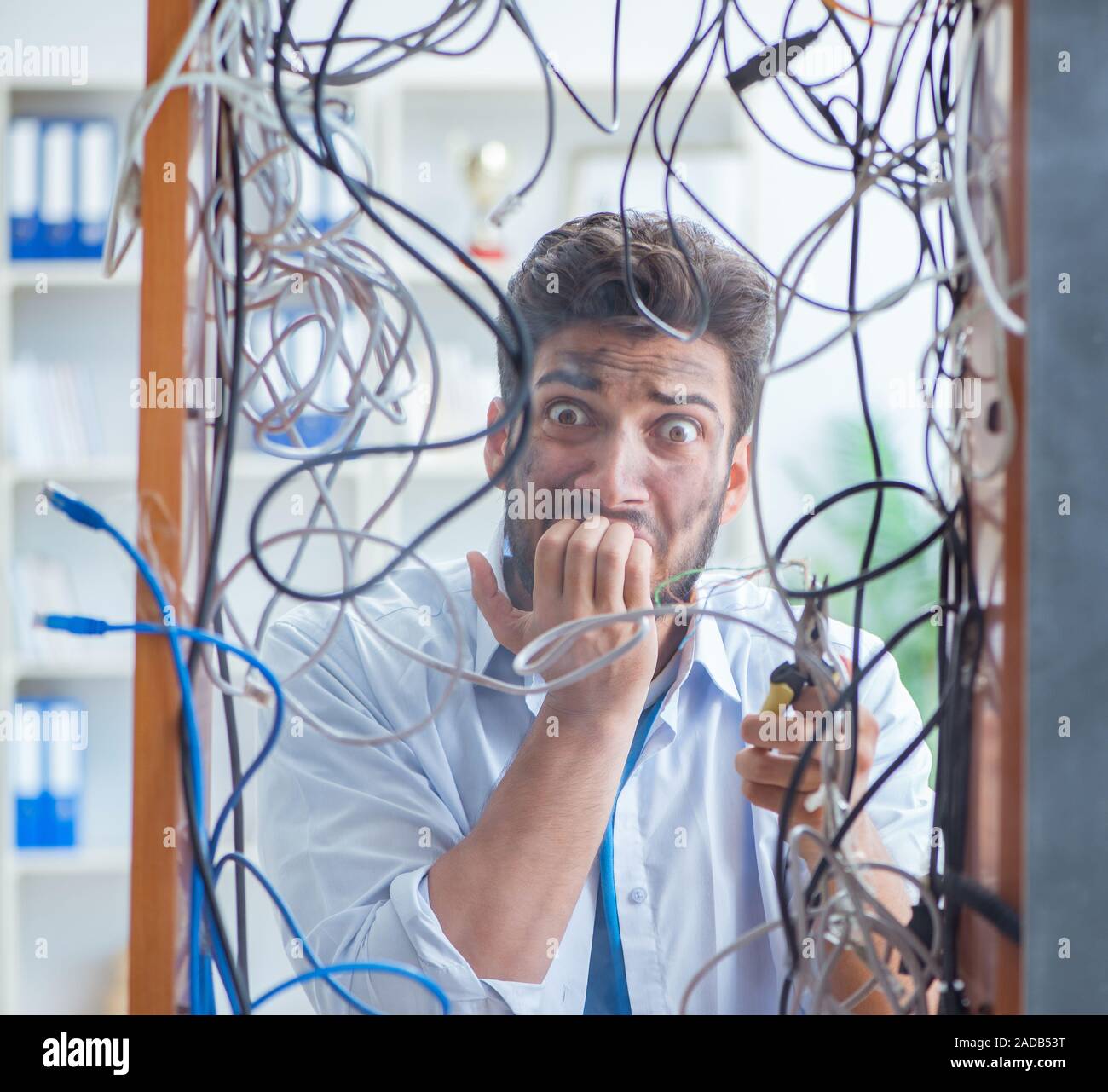 Electrician trying to untangle wires in repair concept Stock Photo - Alamy