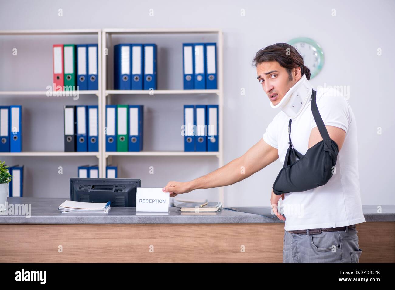 Young man at hospital reception desk Stock Photo - Alamy
