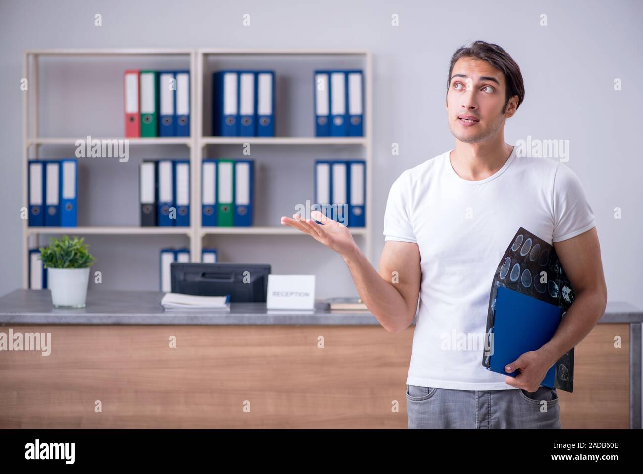 Young man at hospital reception desk Stock Photo - Alamy