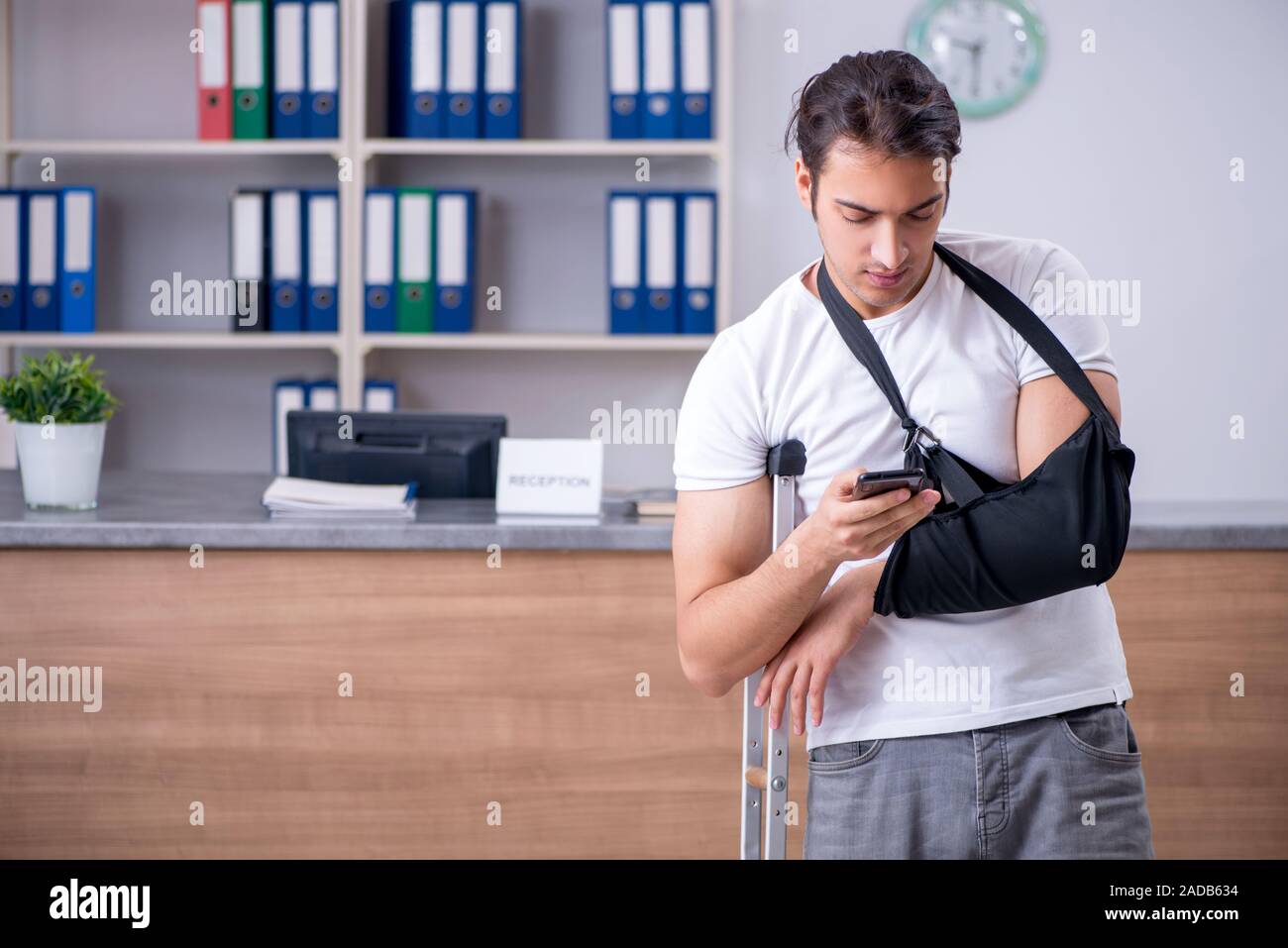 Young man at hospital reception desk Stock Photo - Alamy