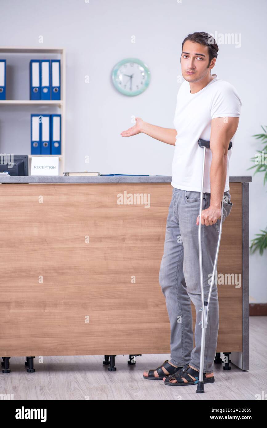 Young man at hospital reception desk Stock Photo - Alamy