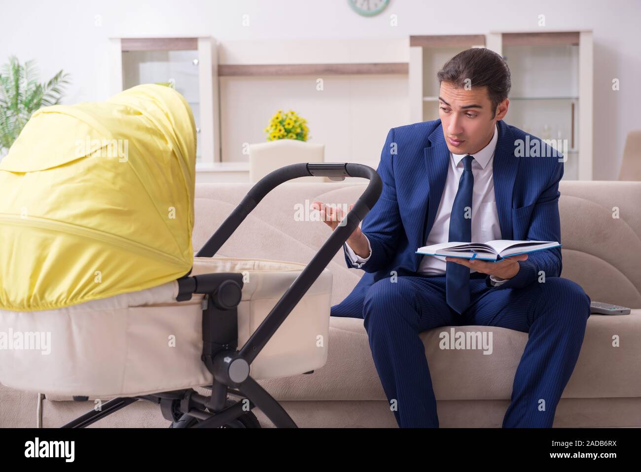 Young Businessman looking after baby Stock Photo - Alamy