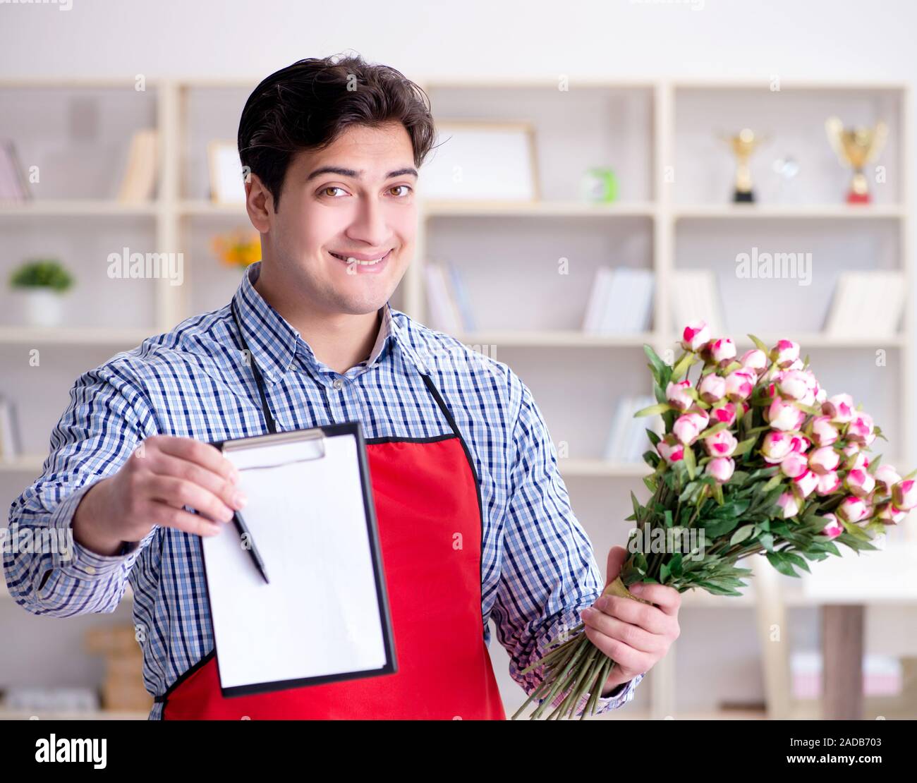 The flower shop assistant offering a bunch of flowers Stock Photo - Alamy