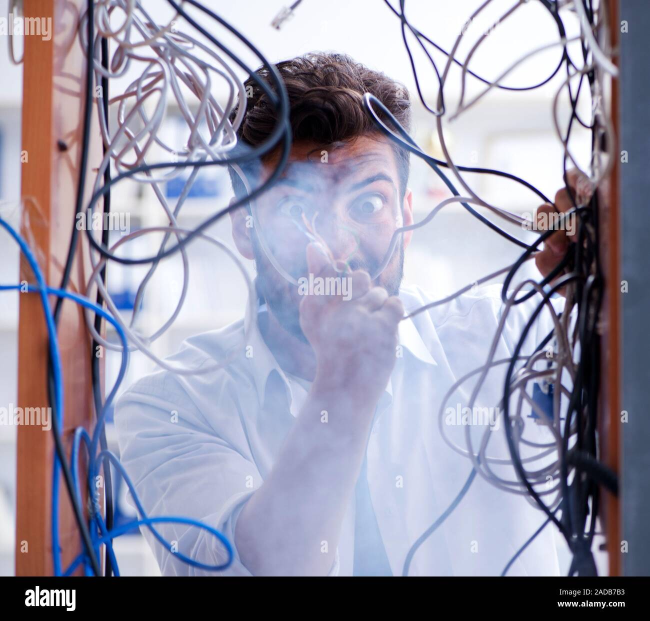 Electrician trying to untangle wires in repair concept Stock Photo - Alamy