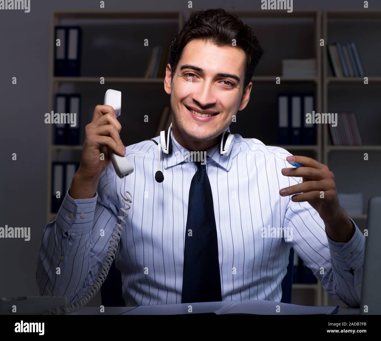 Call center operator talking to customer during night shift Stock Photo ...