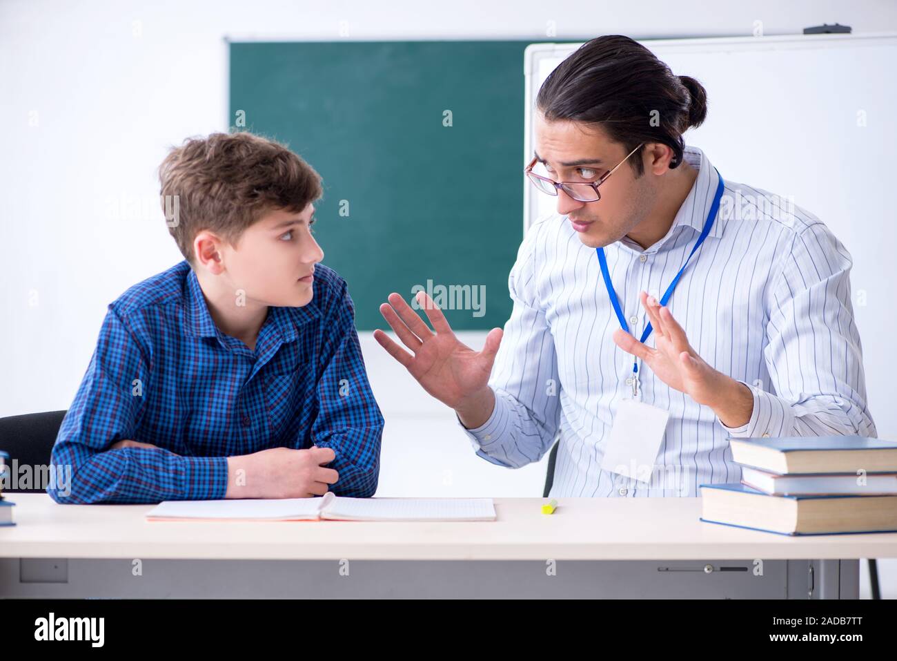 Young male teacher and boy in the classroom Stock Photo - Alamy