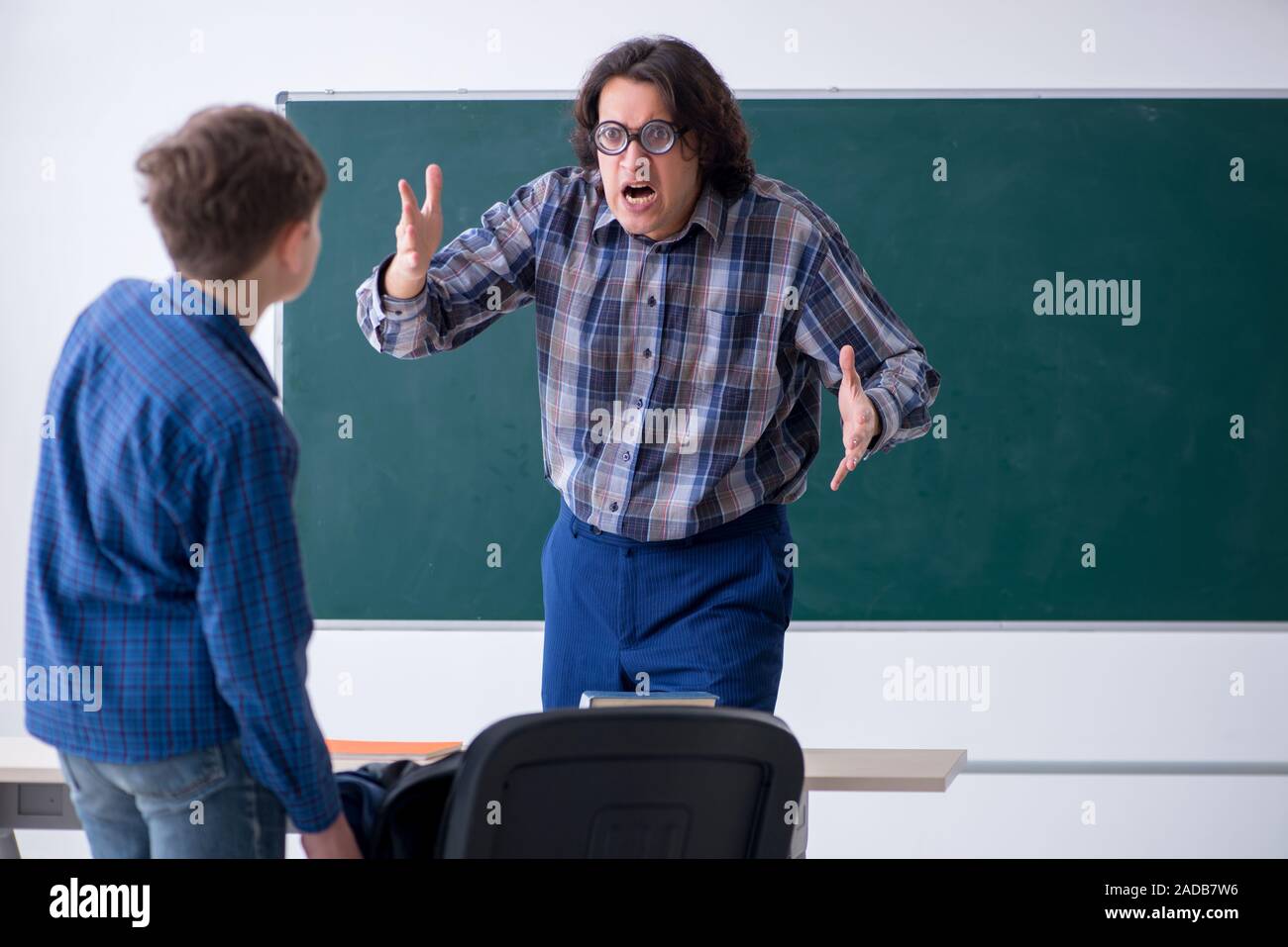 Funny male teacher and boy in the classroom Stock Photo - Alamy