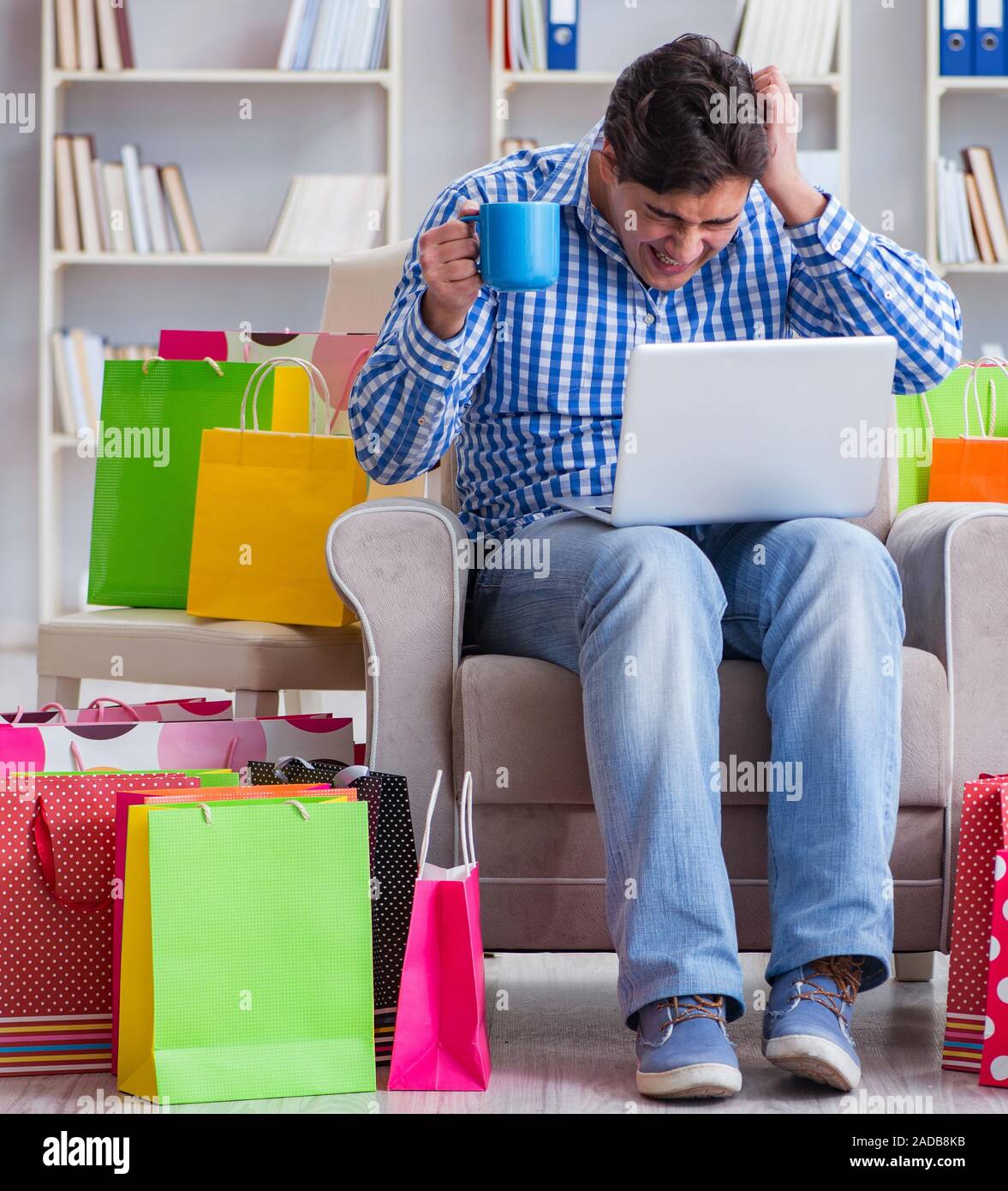 Young man after excessive shopping at home Stock Photo - Alamy