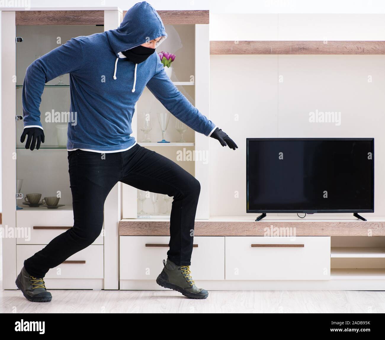 Man burglar stealing tv set from house Stock Photo - Alamy