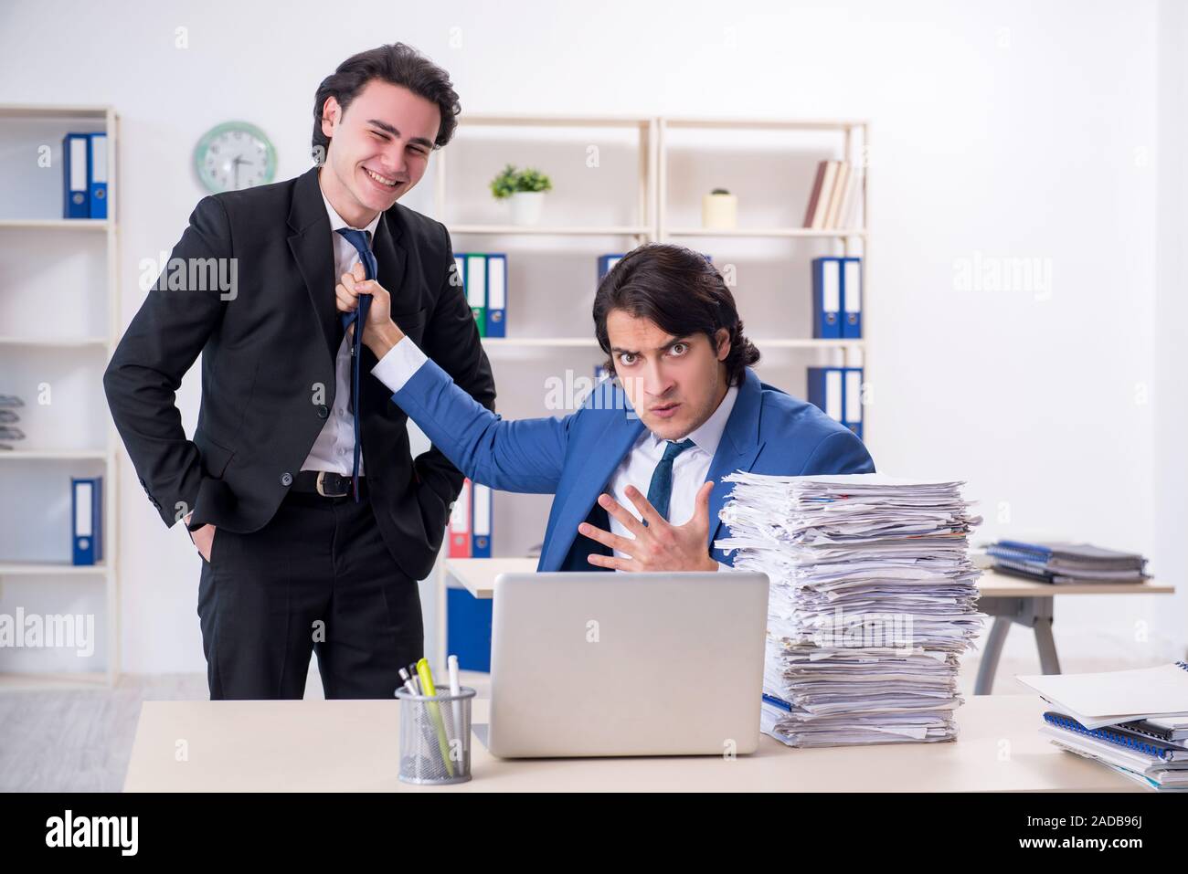 Two male colleagues unhappy with excessive work Stock Photo - Alamy