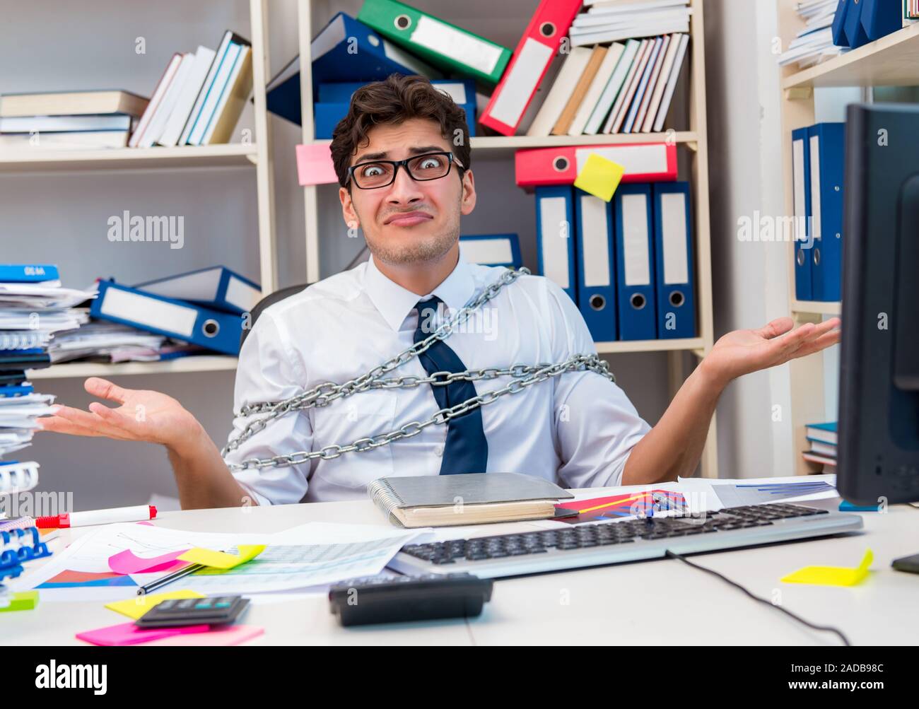 Employee attached and chained to his desk with chain Stock Photo - Alamy