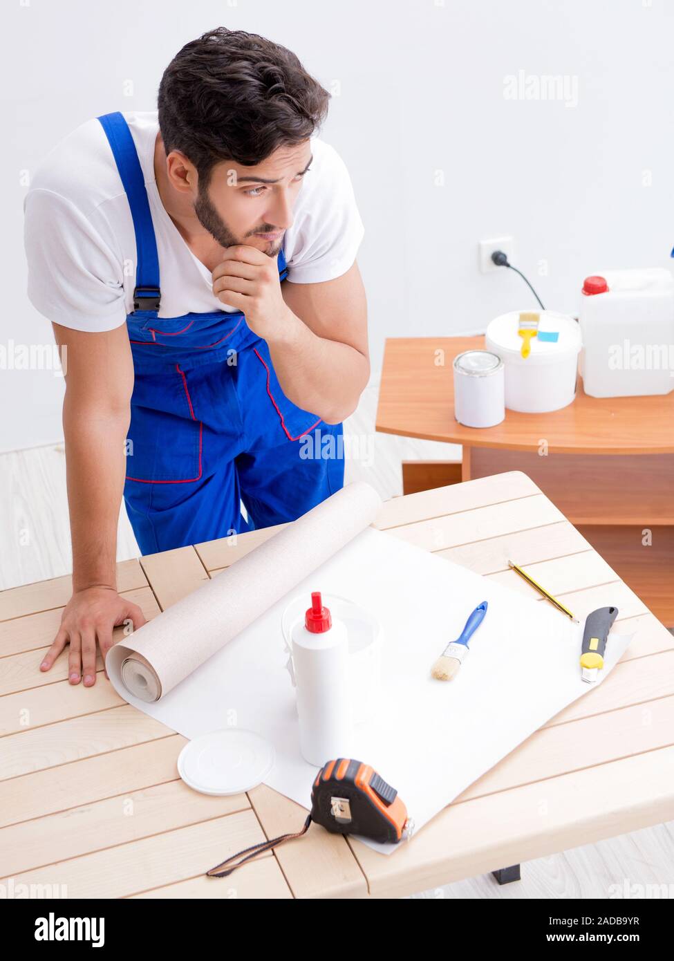 Worker working on wallpaper during refurbishment Stock Photo - Alamy