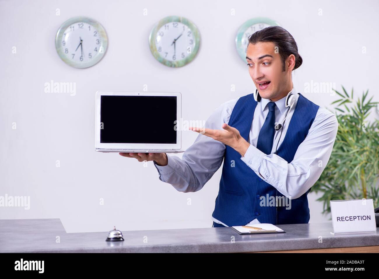 Young man receptionist at the hotel counter Stock Photo - Alamy