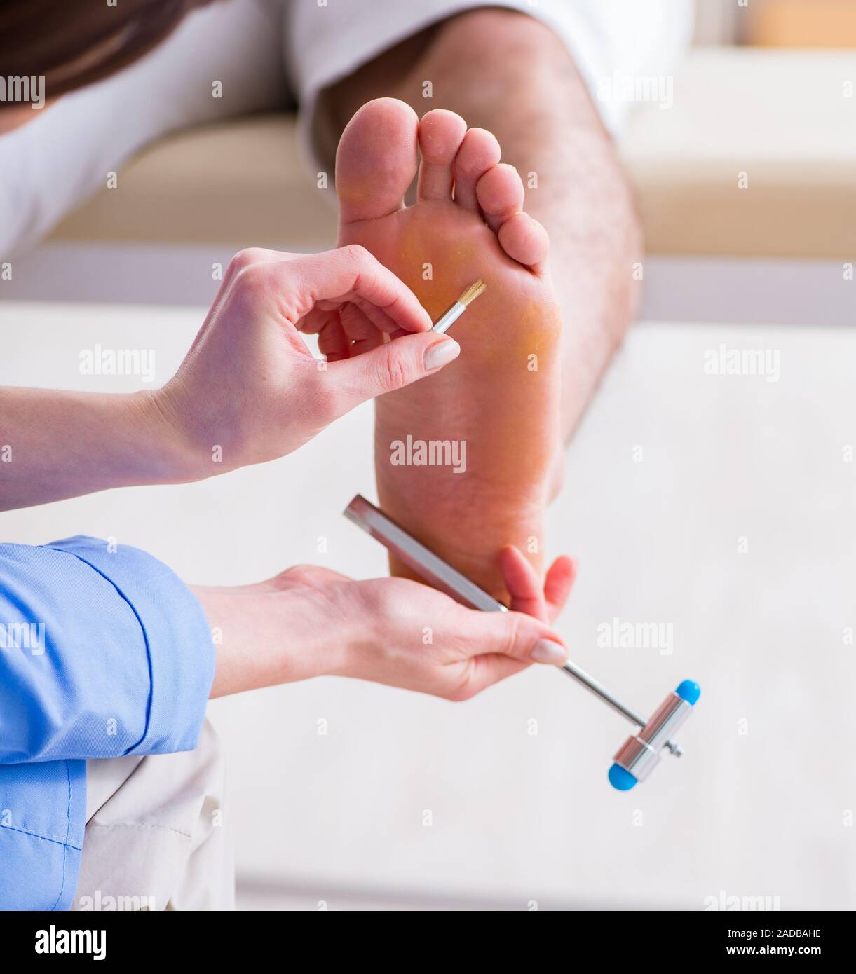 Doctor checking nerve reflexes with hammer Stock Photo - Alamy