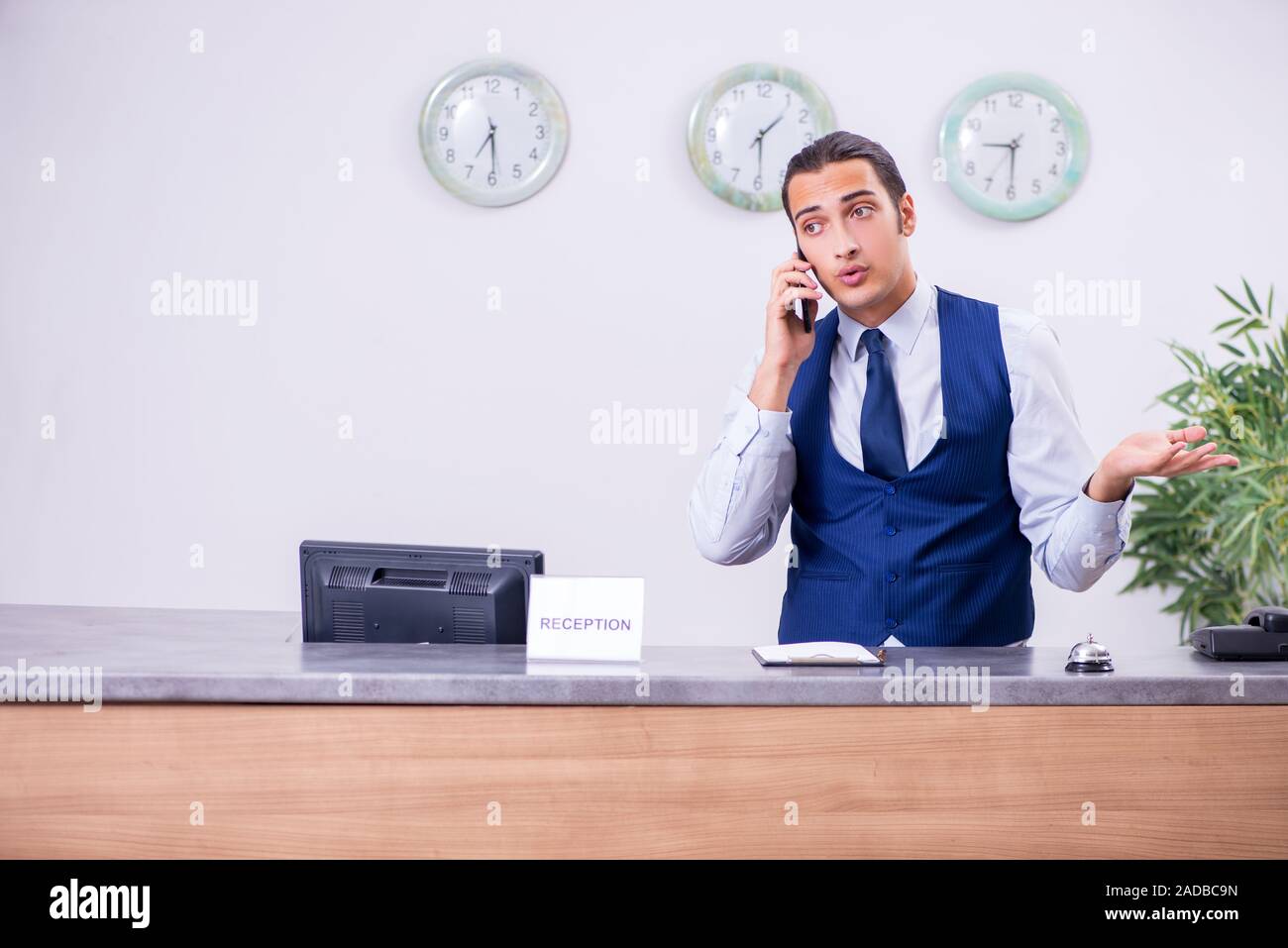 Young man receptionist at the hotel counter Stock Photo - Alamy