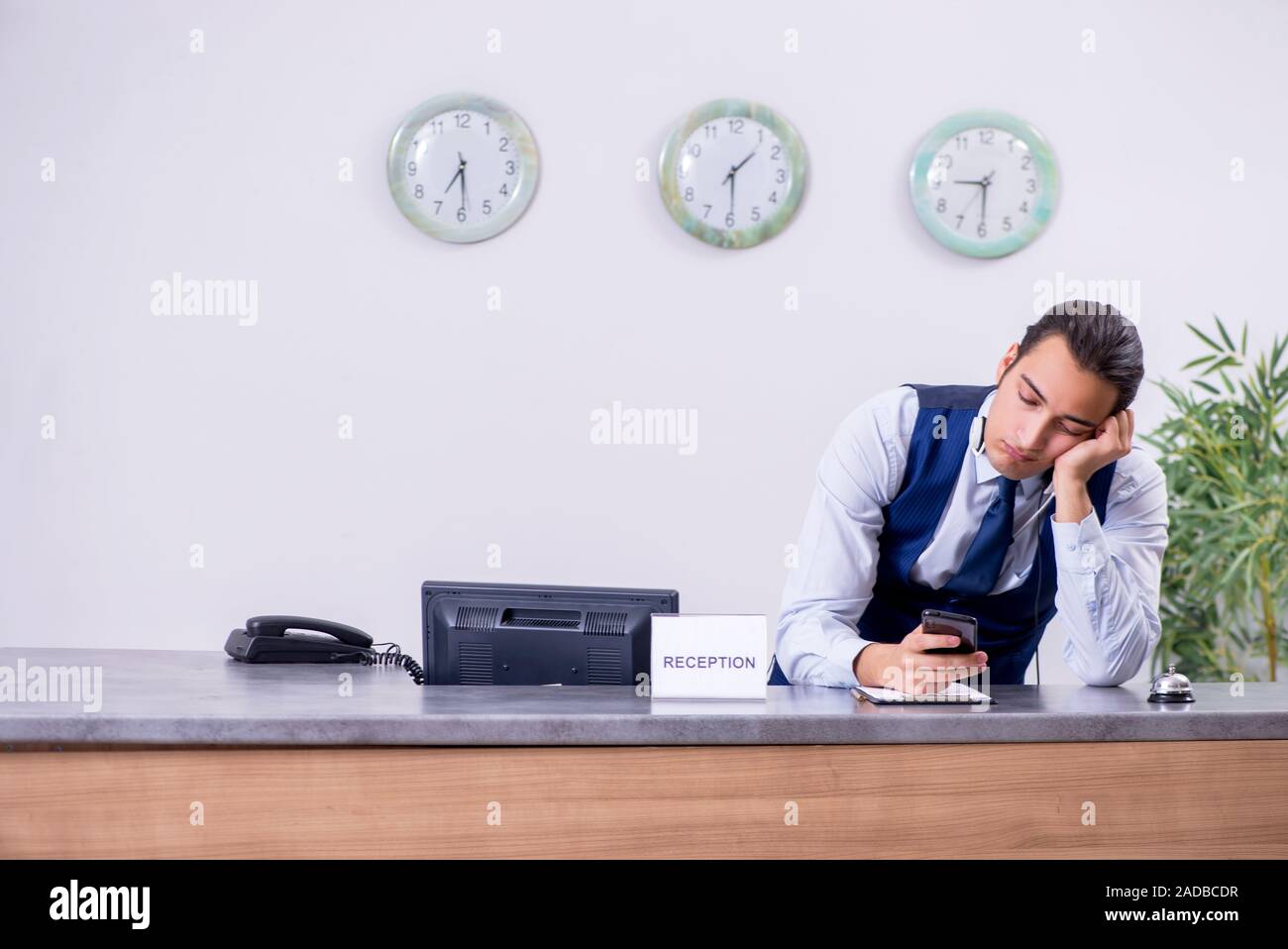 Young man receptionist at the hotel counter Stock Photo - Alamy