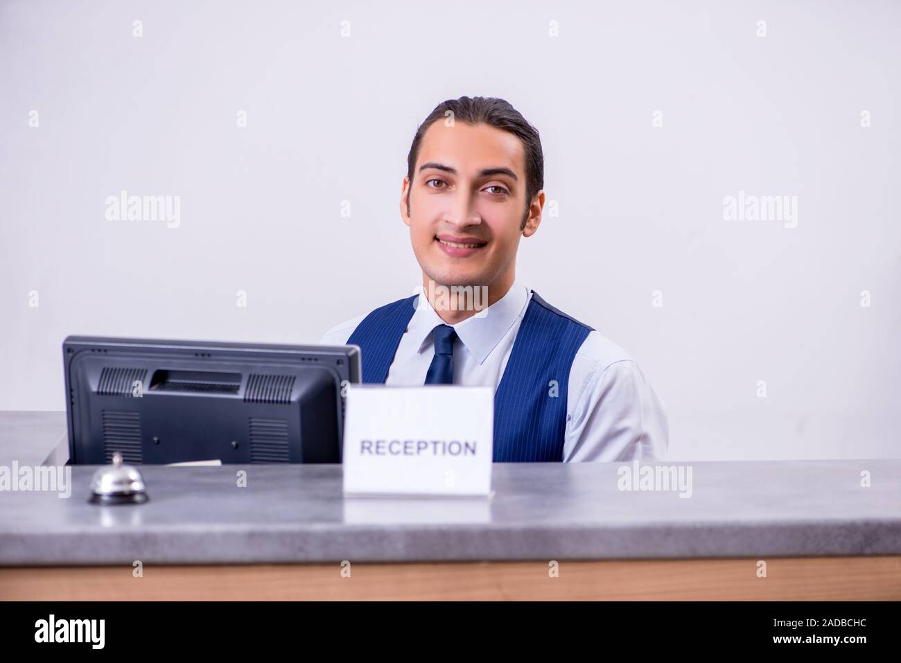 Young man receptionist at the hotel counter Stock Photo - Alamy